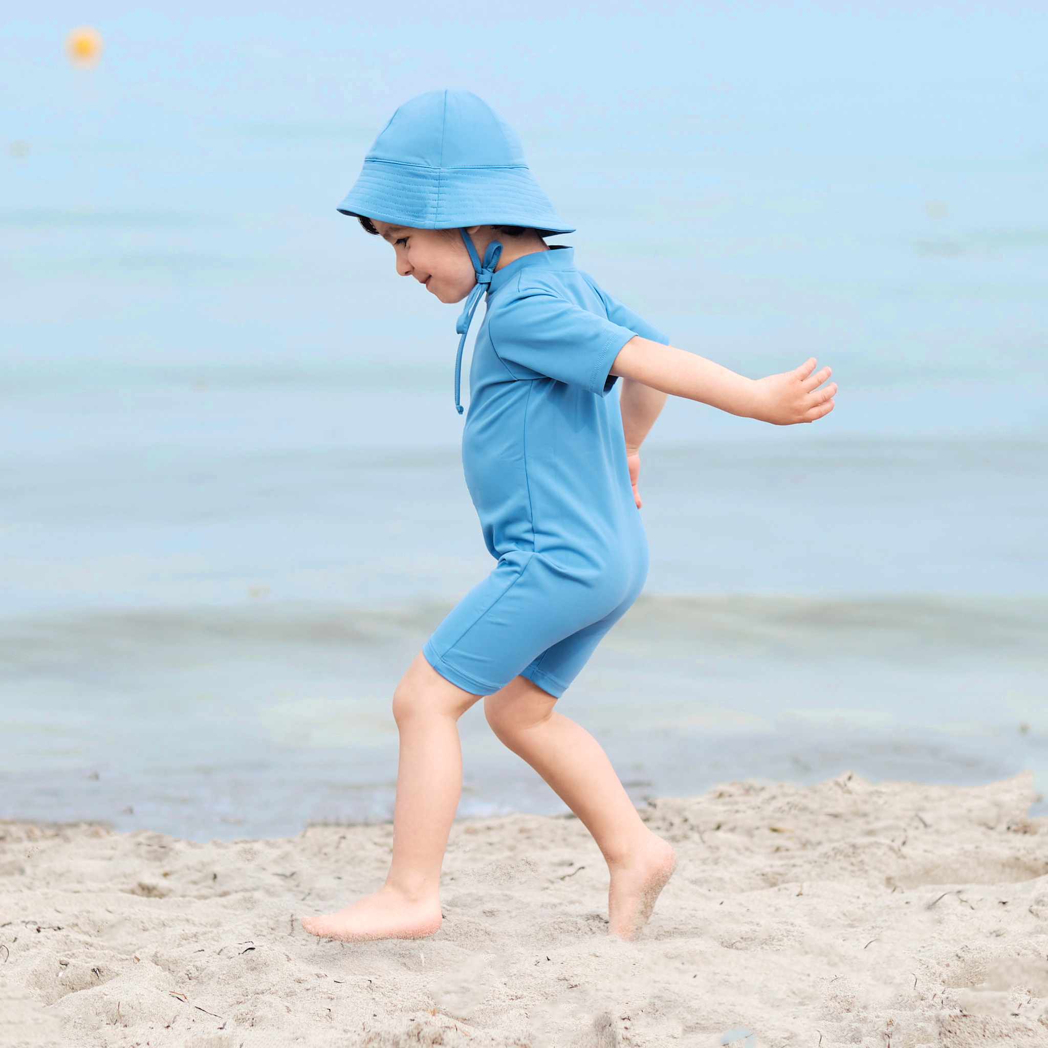 Noe BASIC UV-sunsuit S/S - cornflower - Petit Crabe